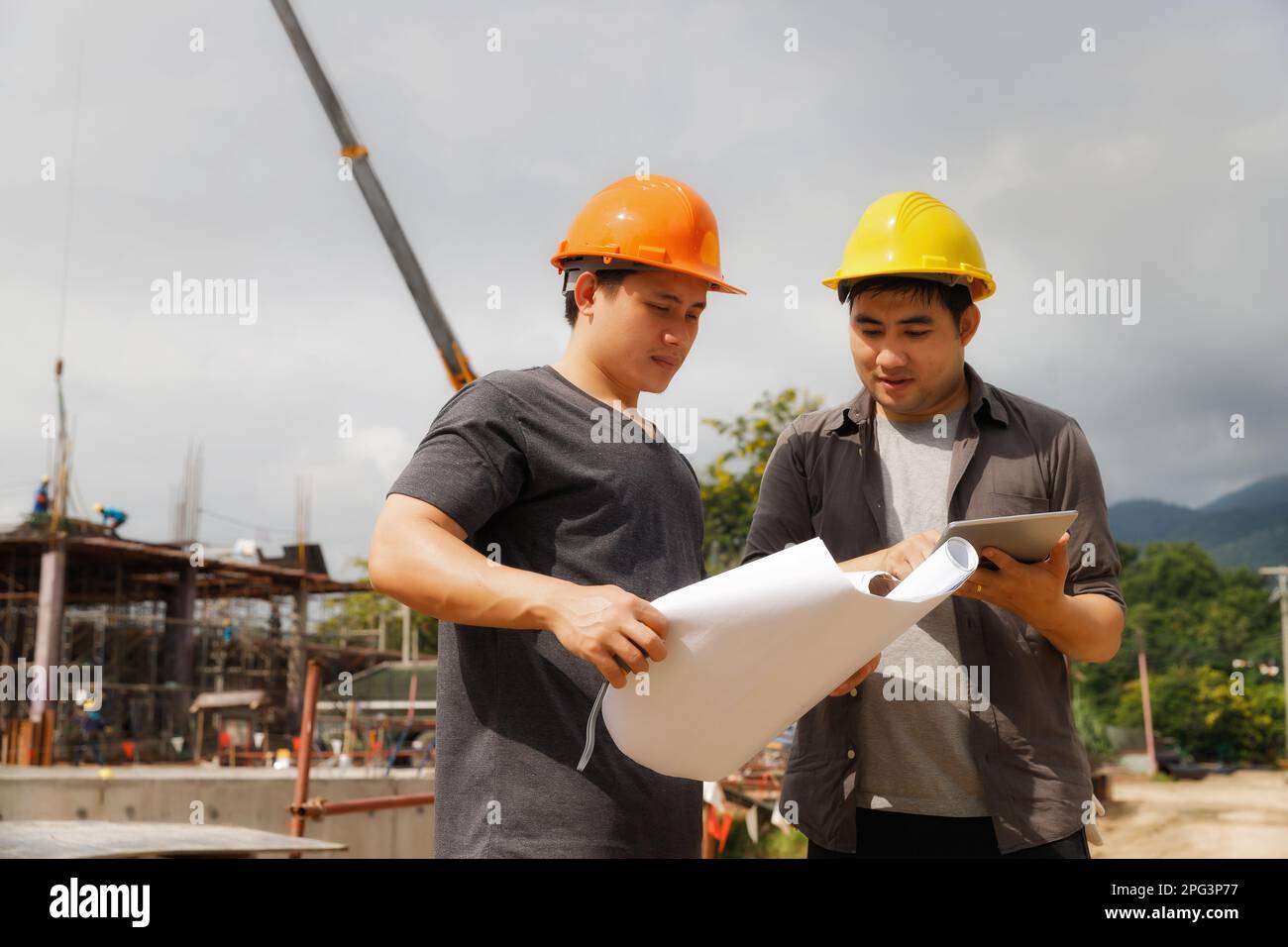 Team of construction workers discussing project details with blueprint ...