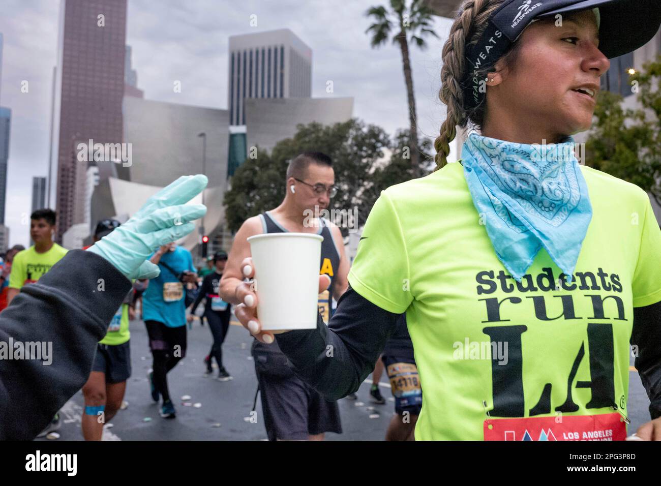 Runners take on water in front of the Dorothy Chandler Pavillon during ...