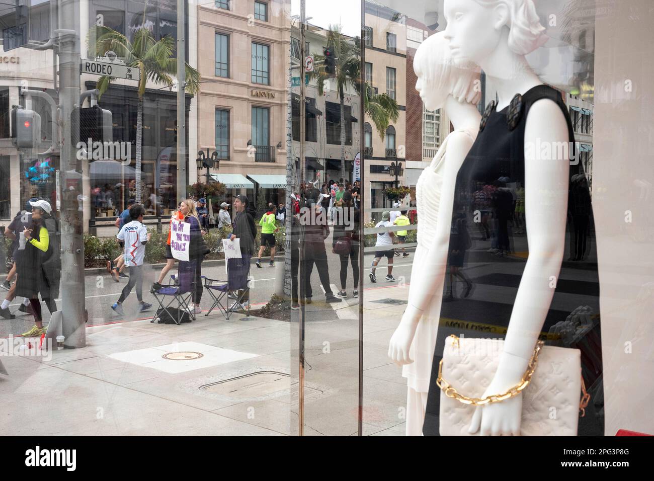 Runners pass by stores along Rodeo Drive in Beverly Hills during the ...