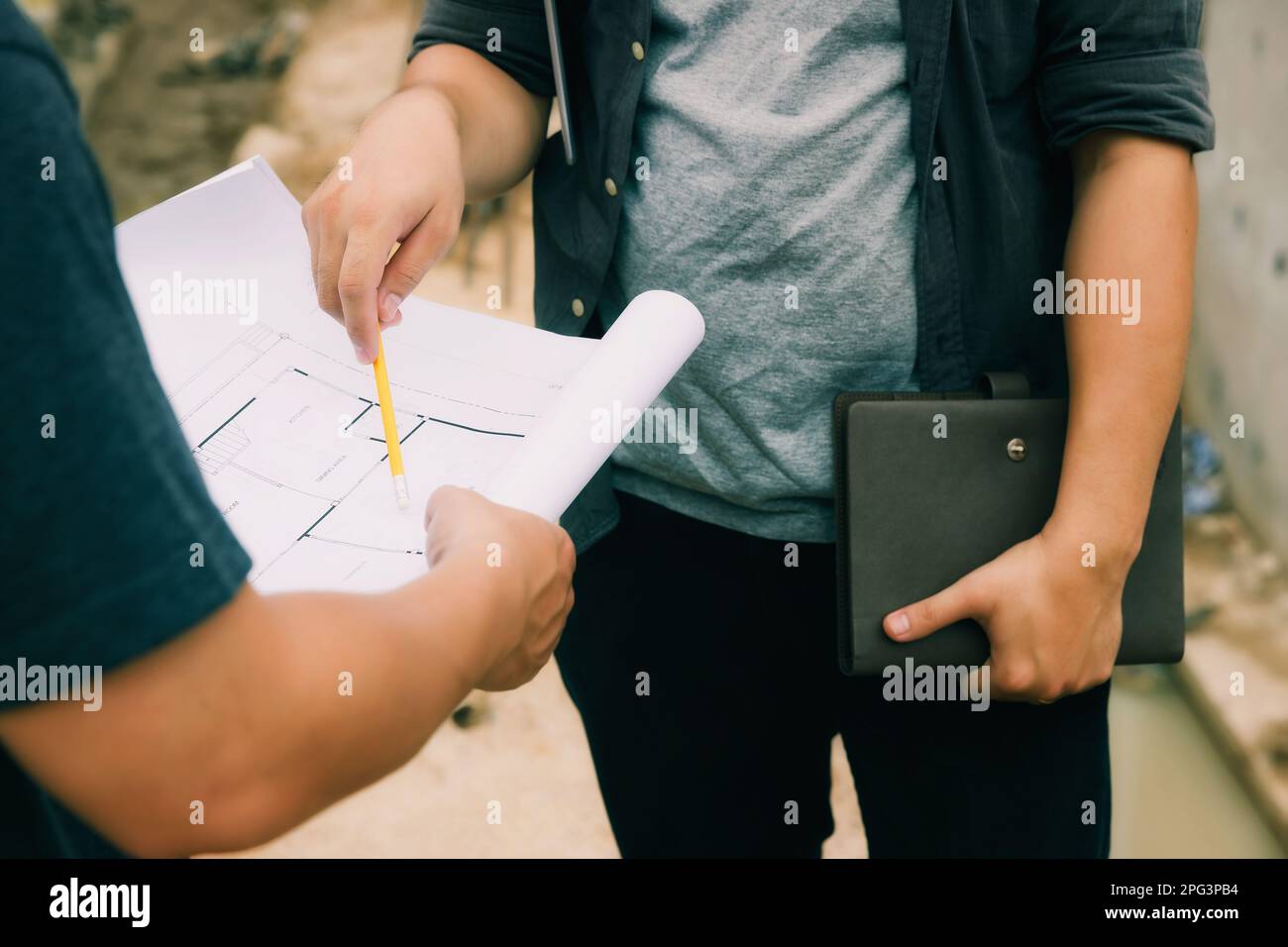 Team of construction workers discussing project details with blueprint ...