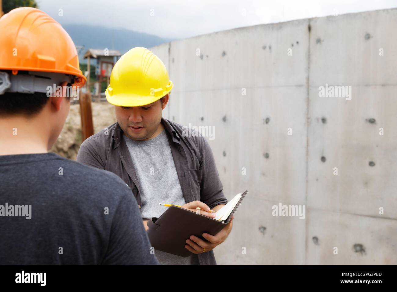 Team of construction workers discussing project details with blueprint ...