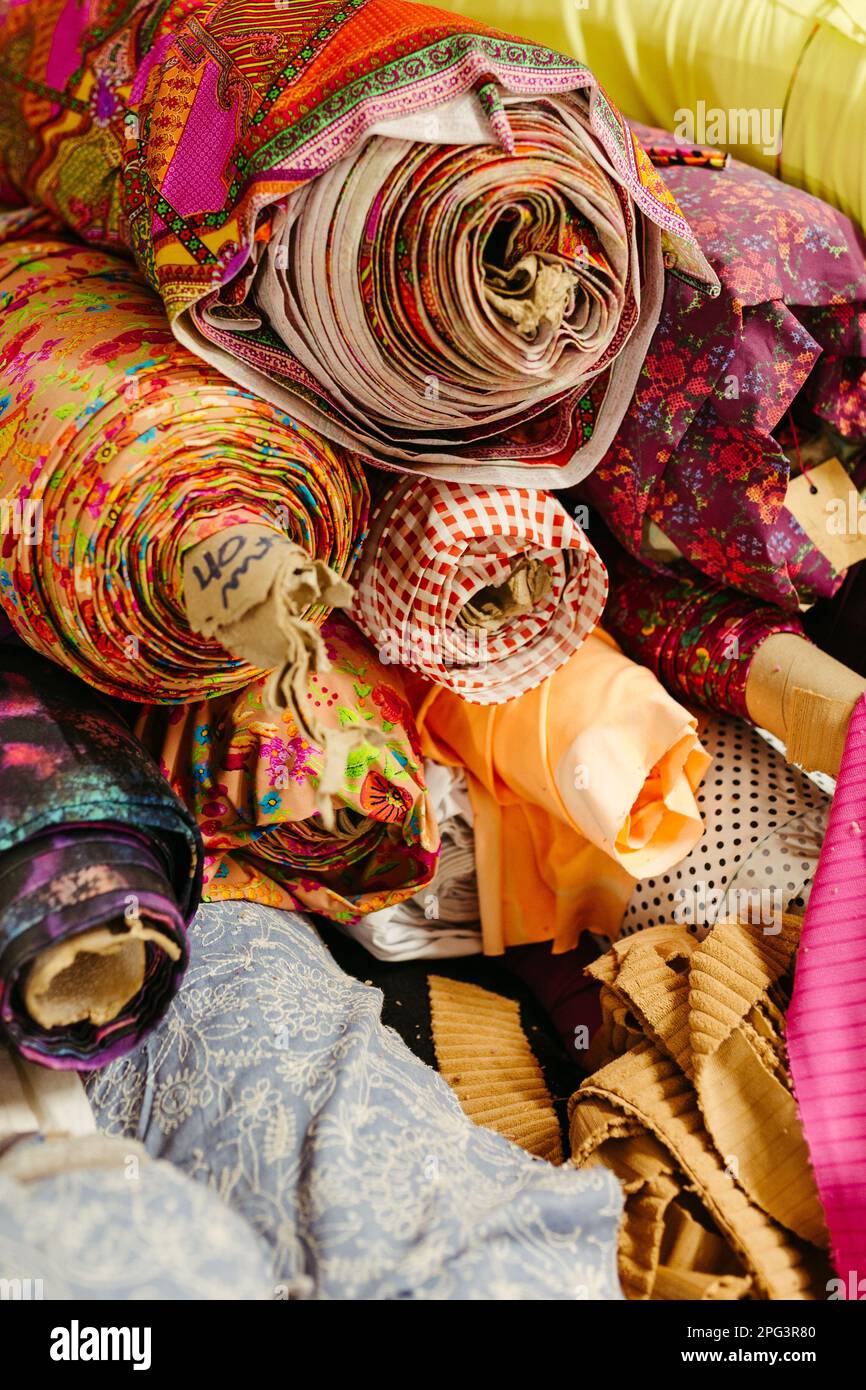 A vibrant collection of multicolored fabric rolls and swatches ...