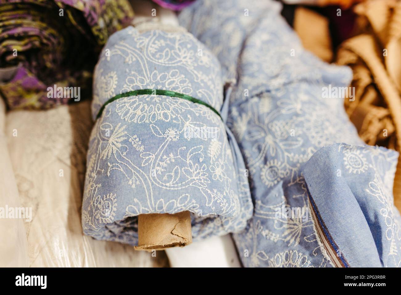 A vibrant collection of multicolored fabric rolls and swatches ...