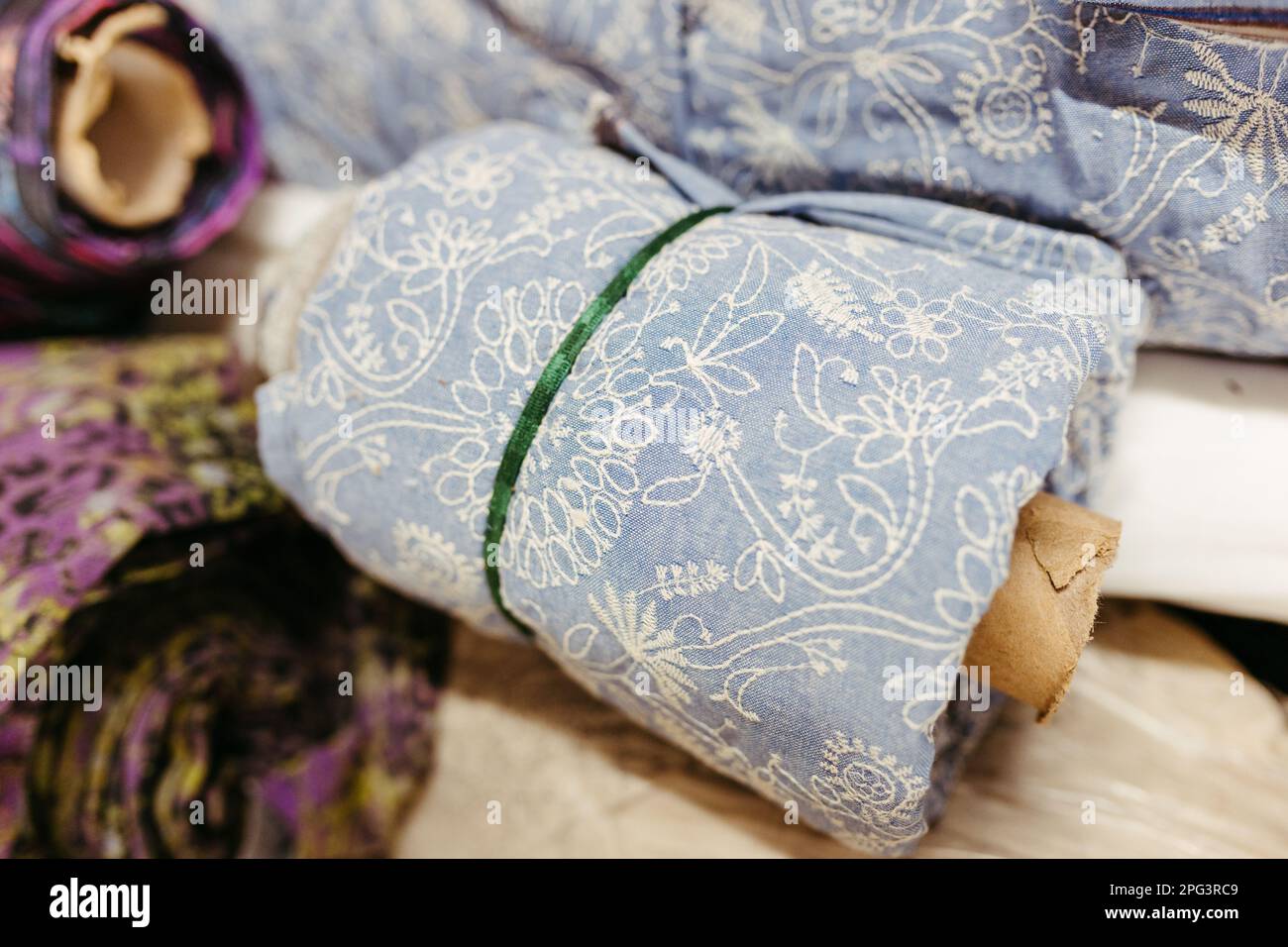 A vibrant collection of multicolored fabric rolls and swatches ...