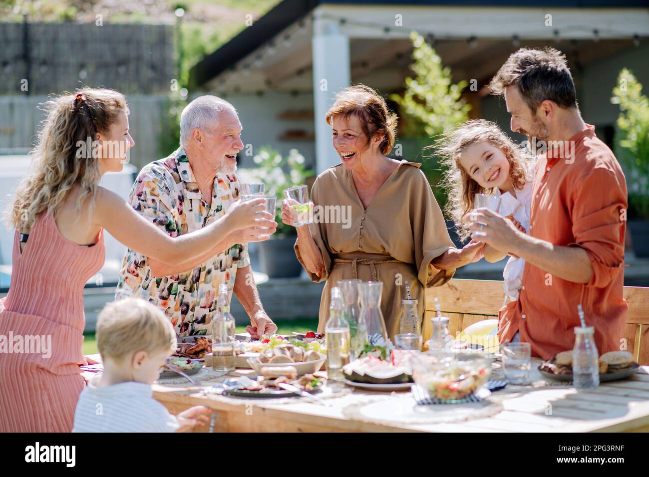Multi generation family having garden party celebration, toasting and ...