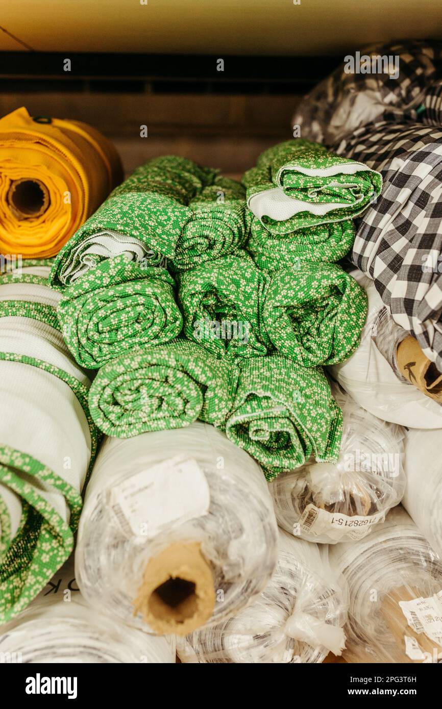 A collection of vibrant green knitted fabric rolls arranged in a neat ...