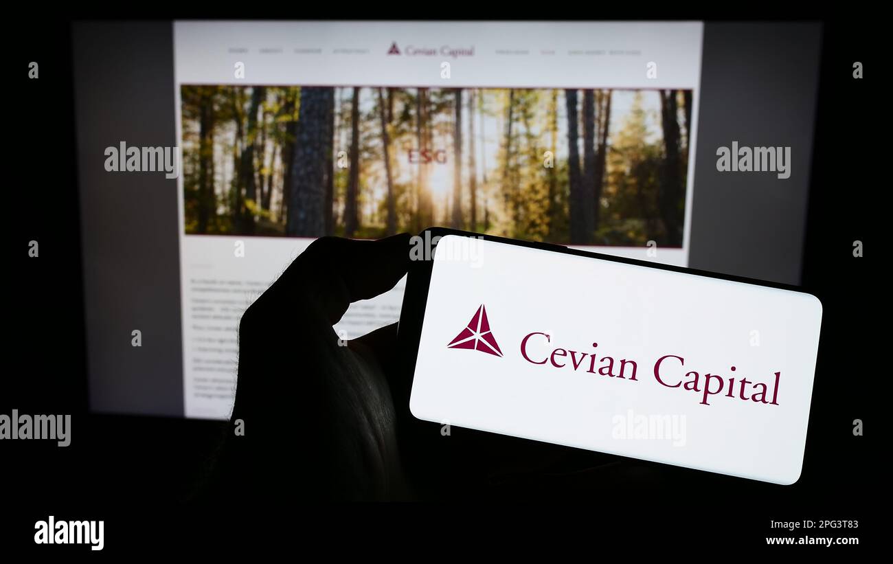 Person holding mobile phone with logo of Swedish investment company Cevian Capital AB on screen ...
