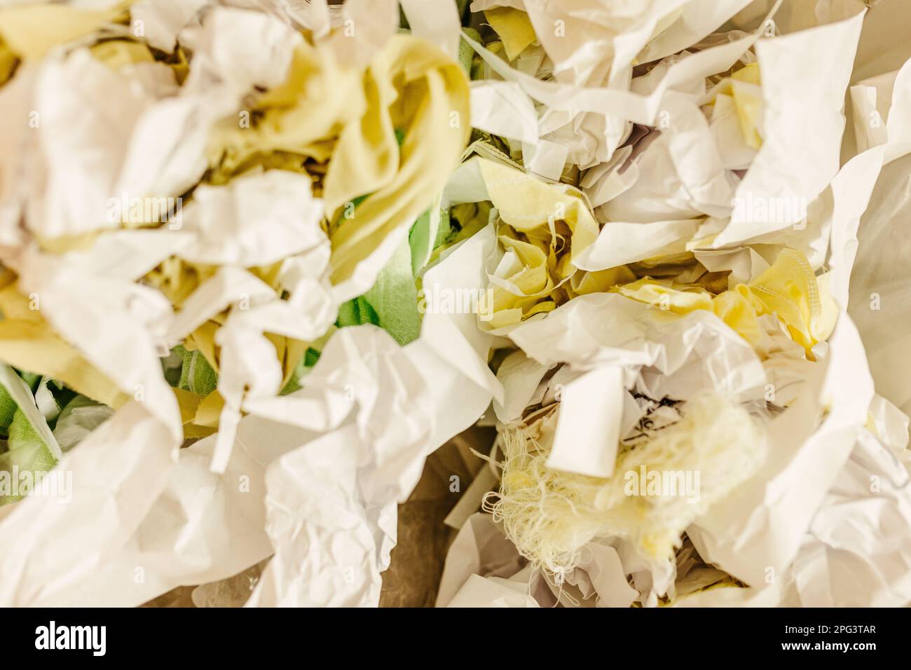 A closeup of white and yellow crumpled papers and swatches background ...
