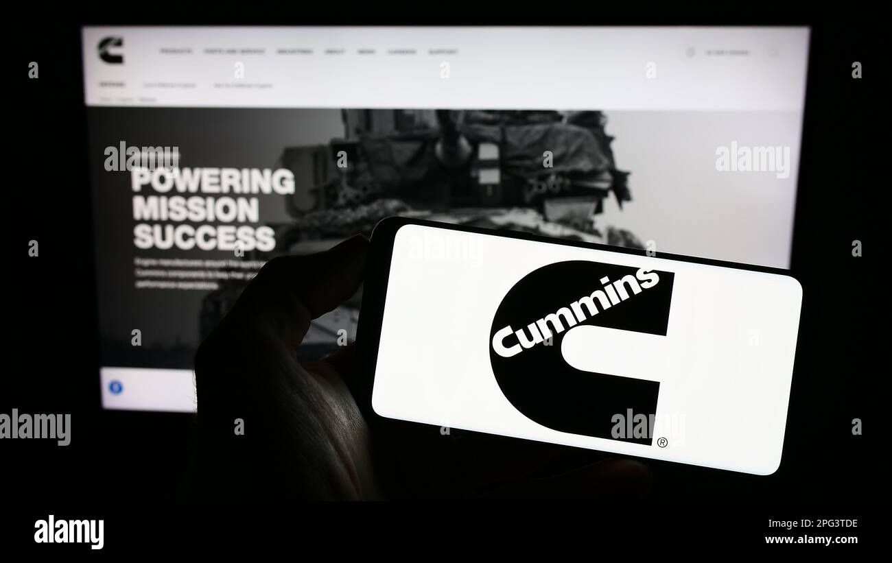 Person holding mobile phone with logo of American manufacturing company ...