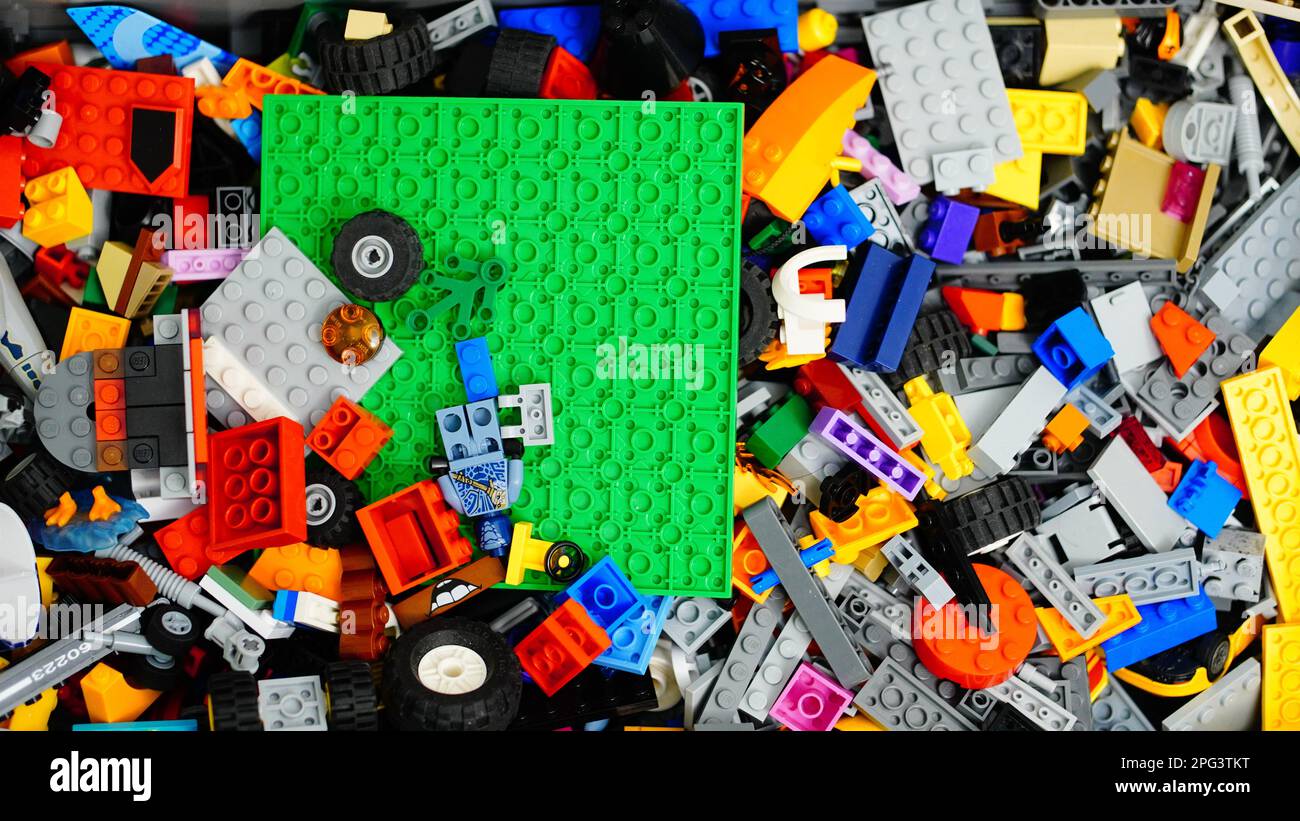 A colorful assortment of plastic LEGO building blocks are scattered in ...