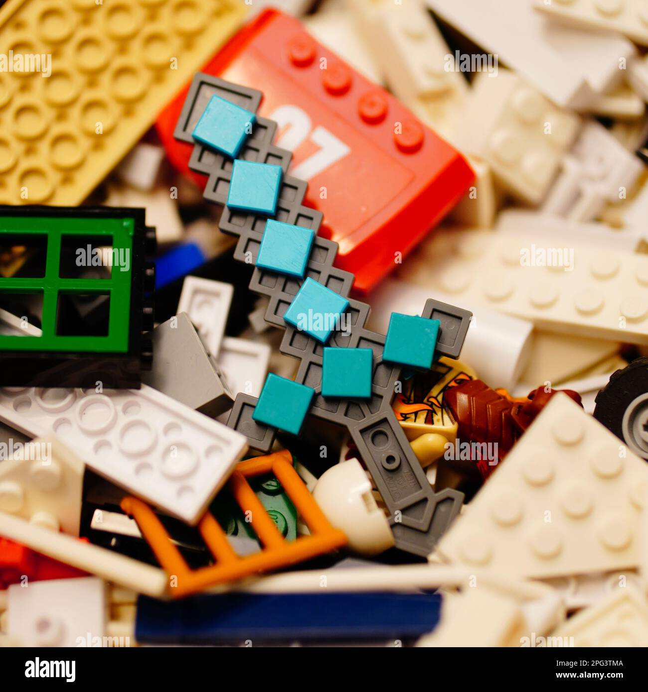 A colorful assortment of Lego blocks in a pile with a sword toy Stock ...