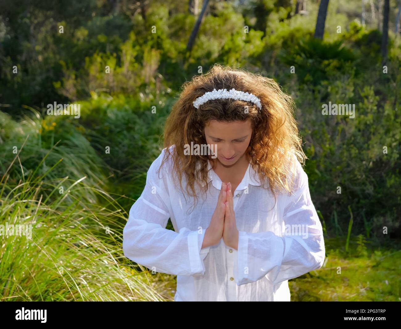 the woman in nature is in a prayer posture Stock Photo - Alamy