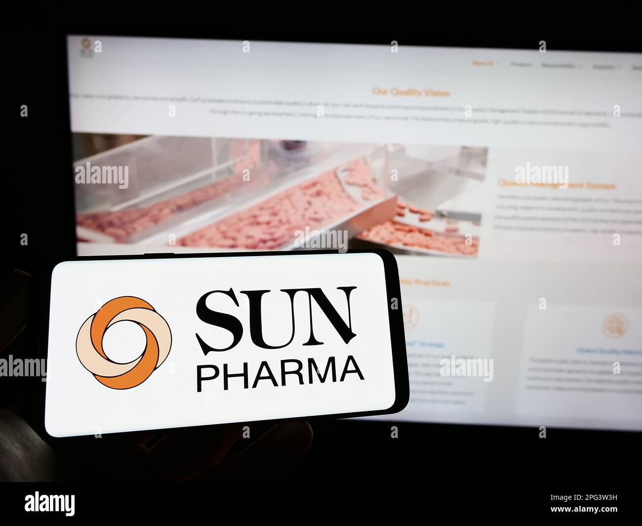 Person holding mobile phone with logo of Indian pharmaceutical company ...