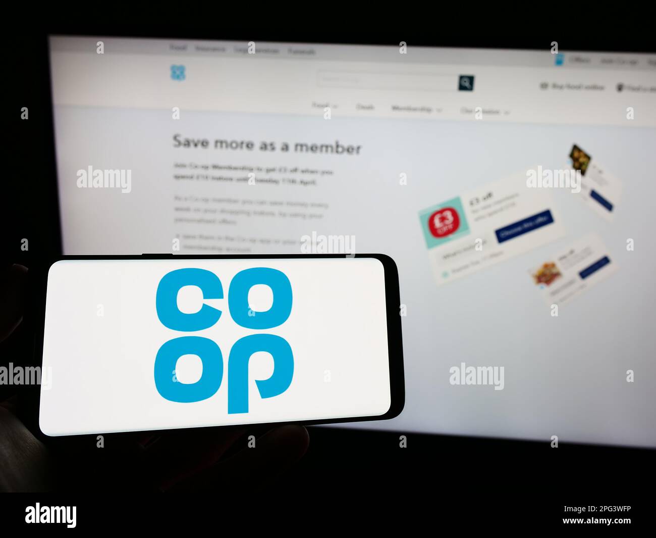 Person holding mobile phone with logo of retail company Co-operative ...