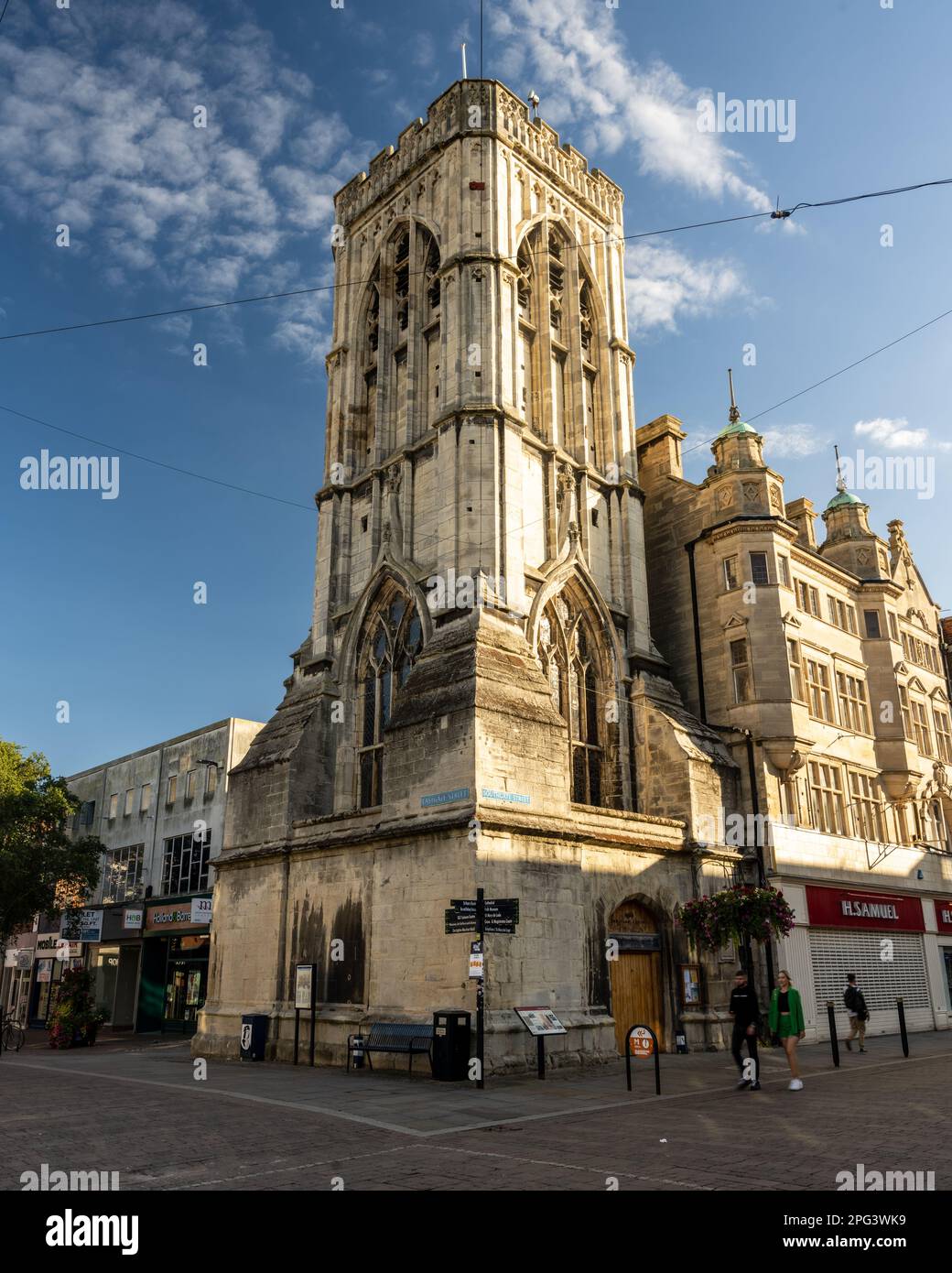 Pedestrians walk past the tower of St Michael's Church in the Eastgate shopping area of ...