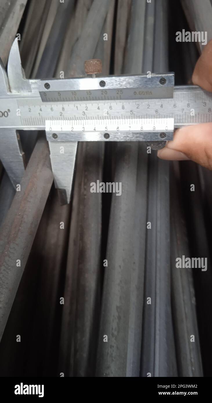 Workers measure the diameter of the iron with a vernier caliper gauge ...