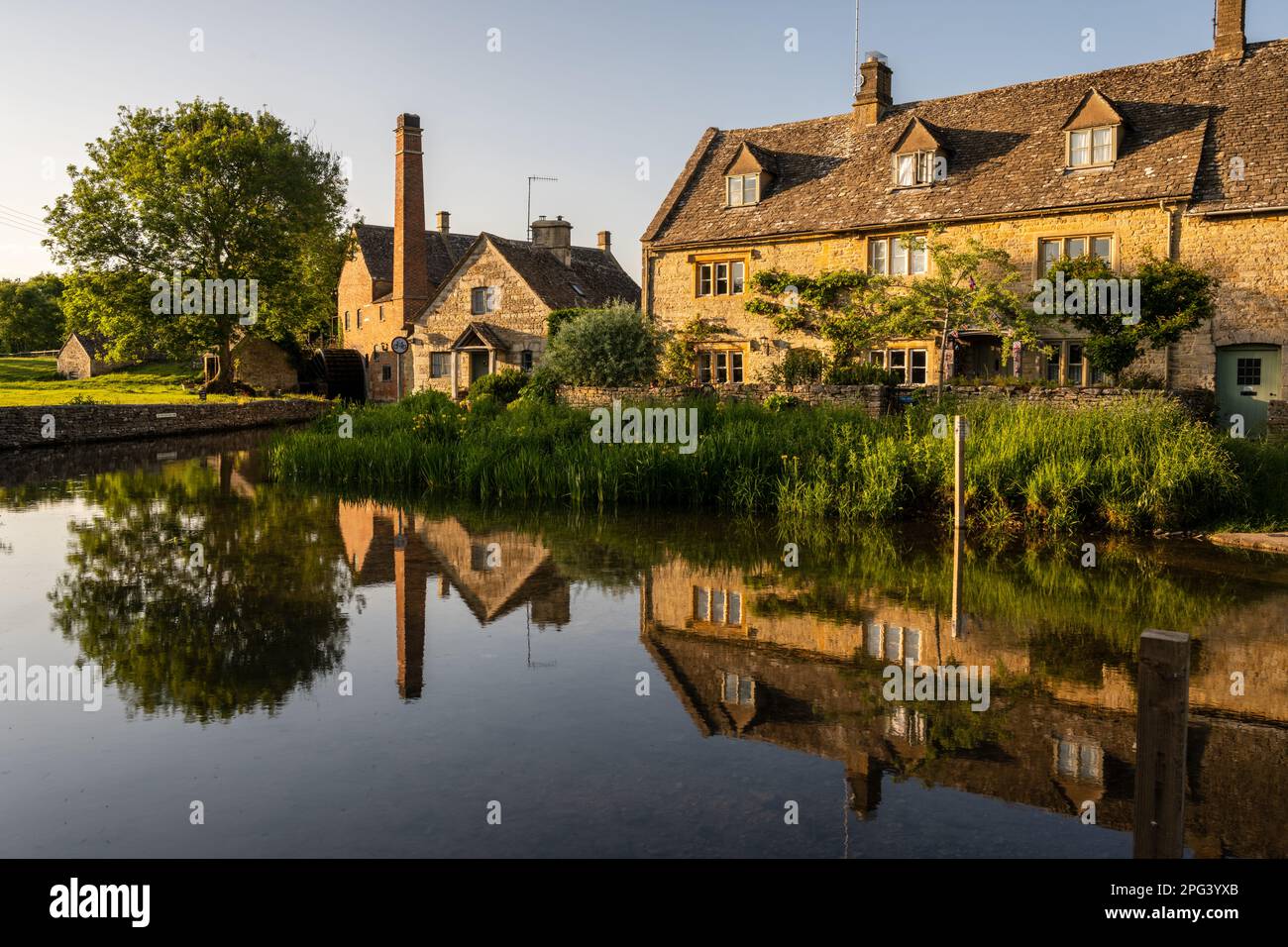 The traditional water mill and stone cottages are reflected in the ...