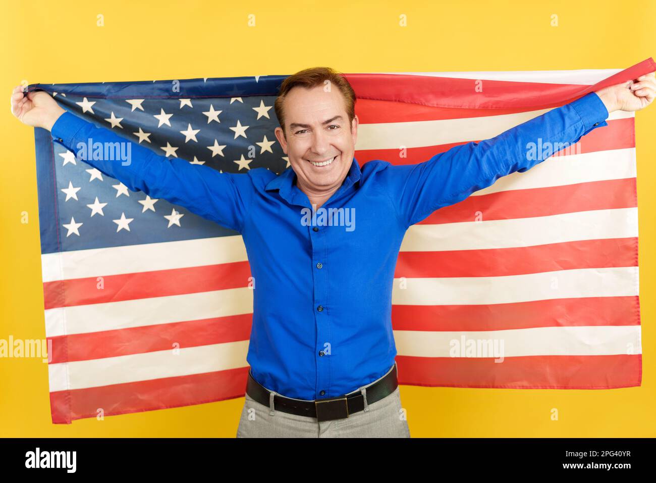 Happy mature man raising a north america national flag Stock Photo - Alamy