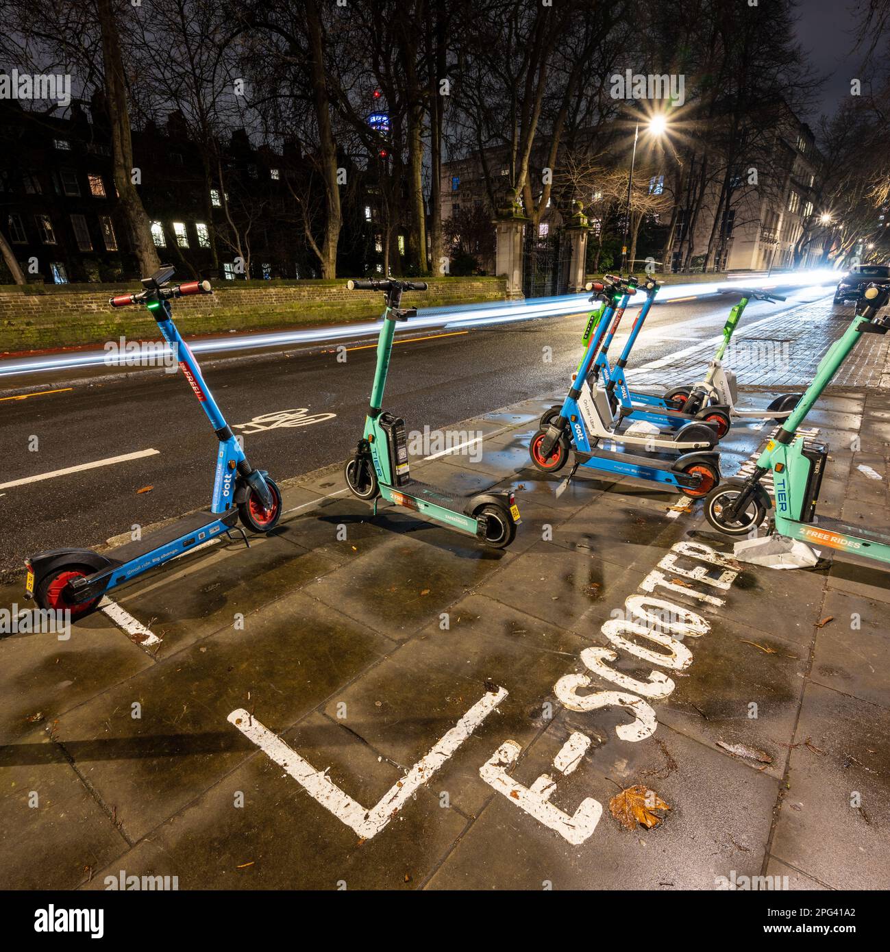 Electric scooters for hire from a variety of providers are parked in a ...