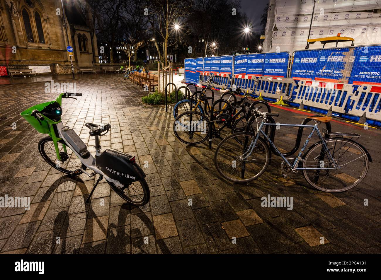 Bicycles are parked beside street trees and benches on Byng Place, a ...