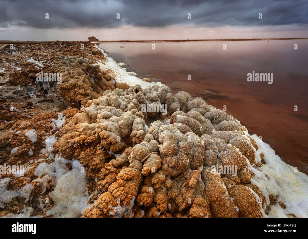 Salt and sluge build up on rocks along the salt evaporation pans of the ...
