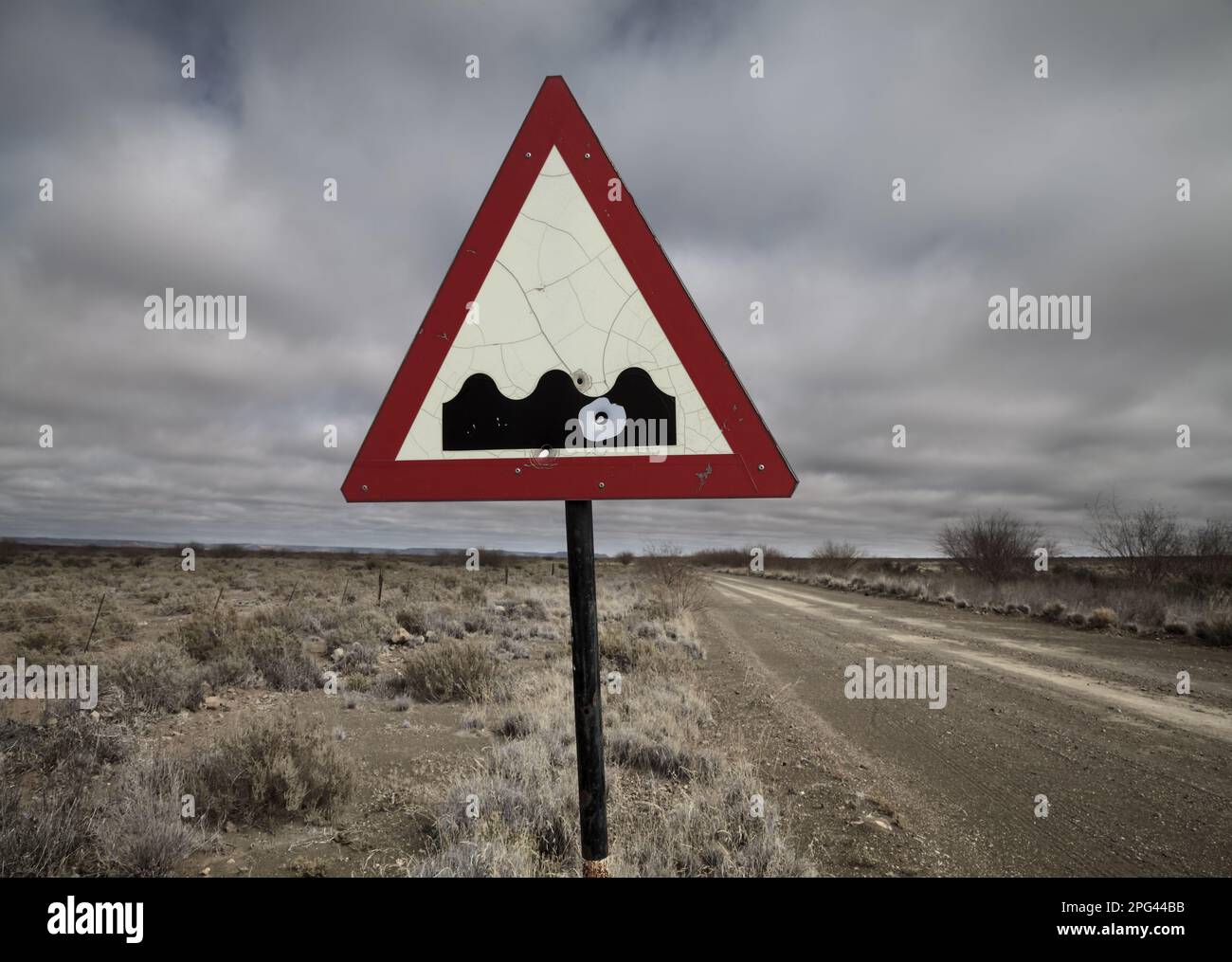 Three Bullet holes decorate a road sign warning motorists of gravel ...