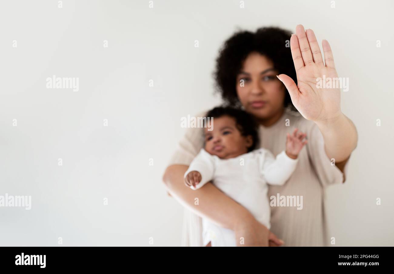 Serious confident young african american lady hold baby in arms, making ...