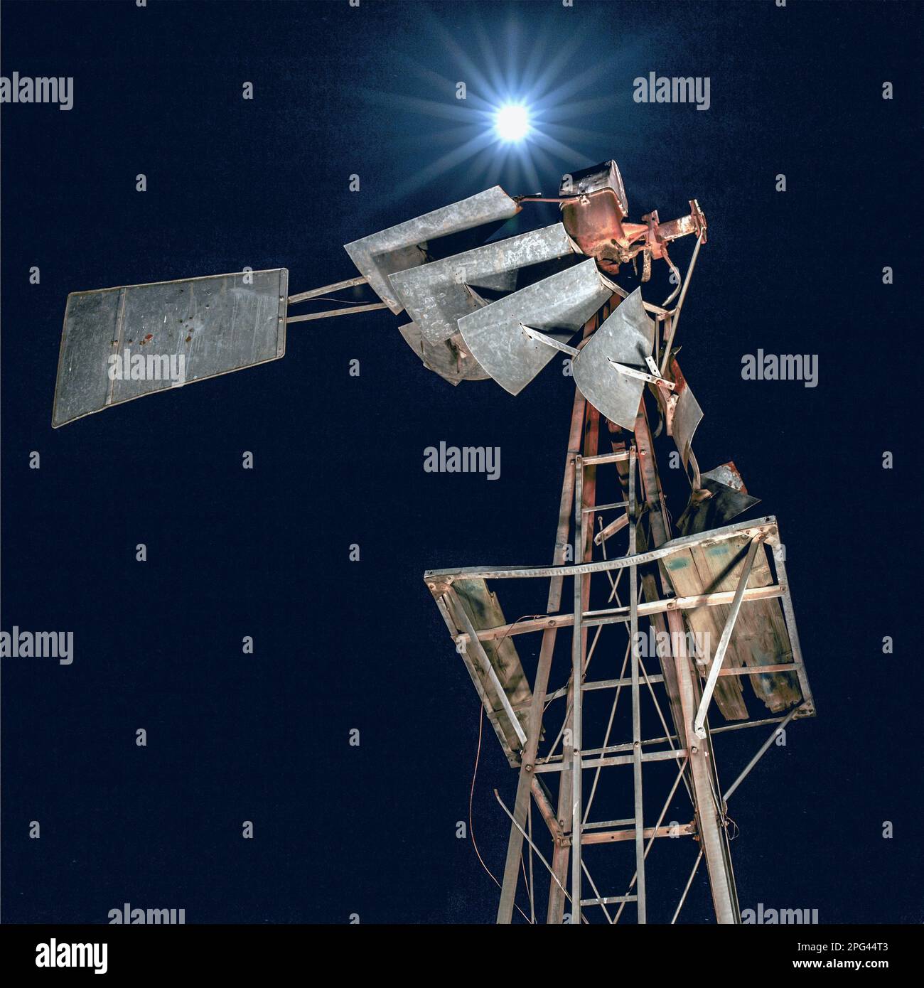 A full moon lies above a broken windmill on a wine farm near Montagu in ...