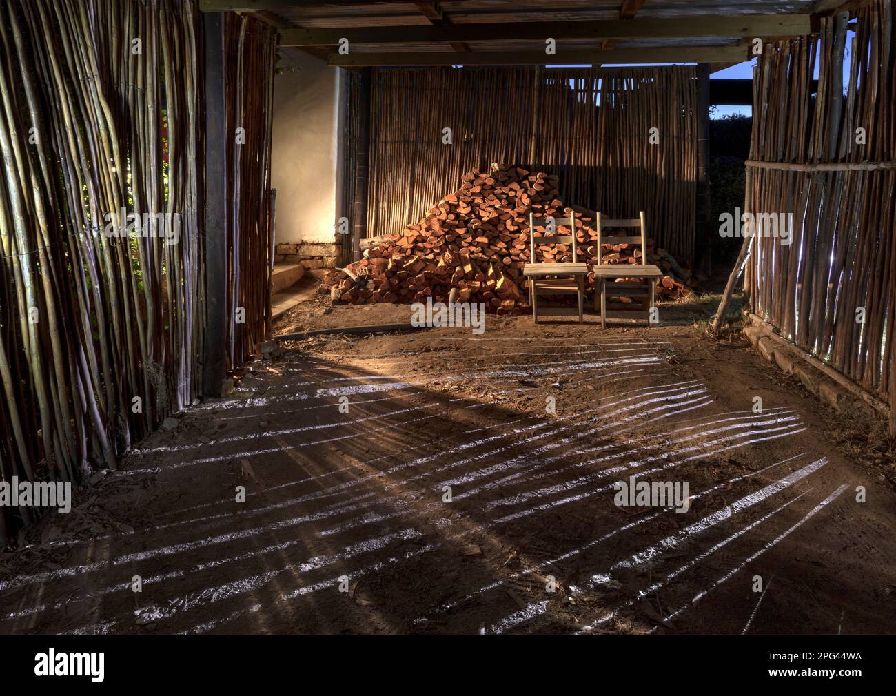 A wooden latte garage with fire wood and chairs on the Watermill Farm ...