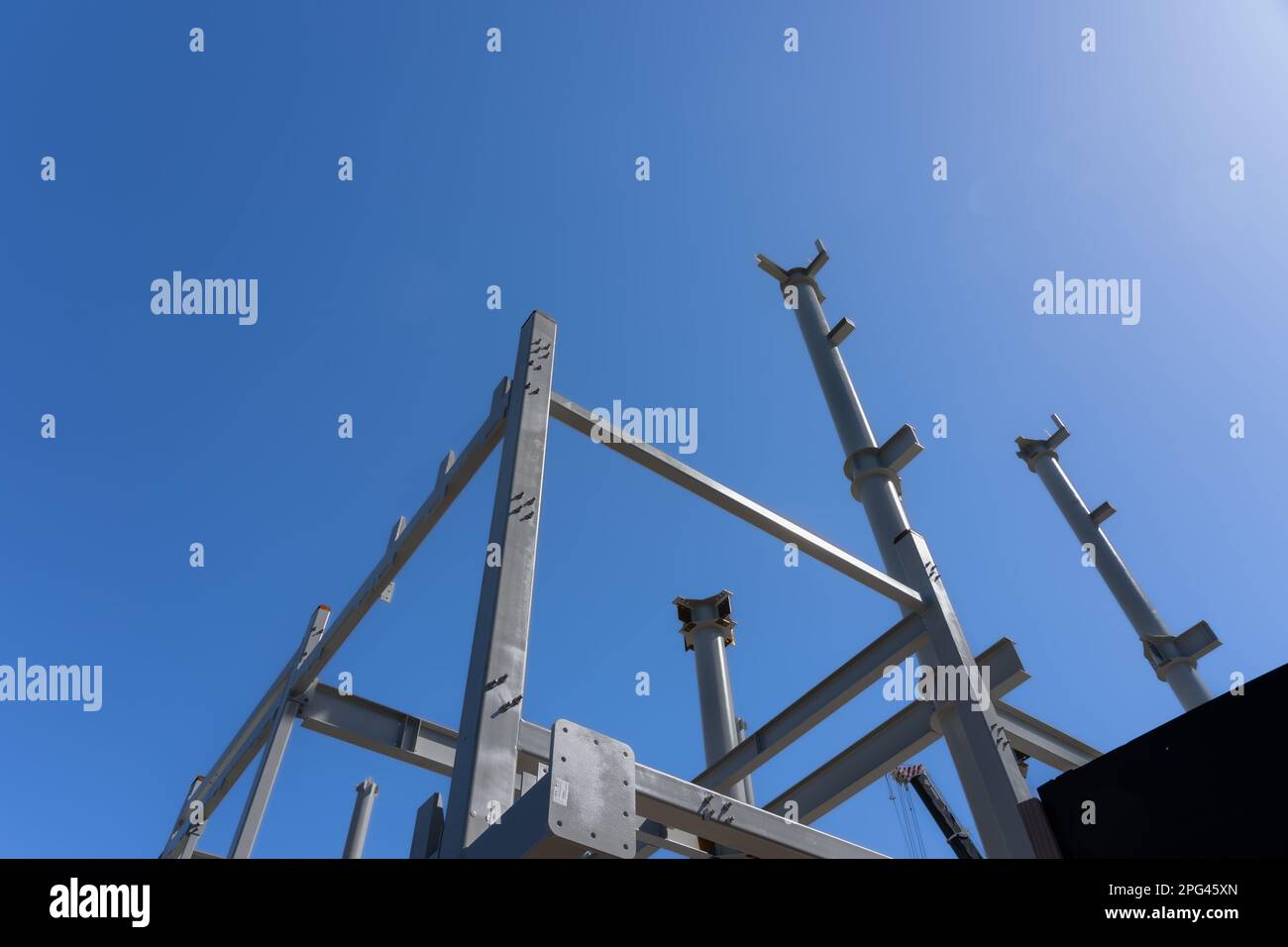 Blue sky over structural steel beams and poles being erected in ...