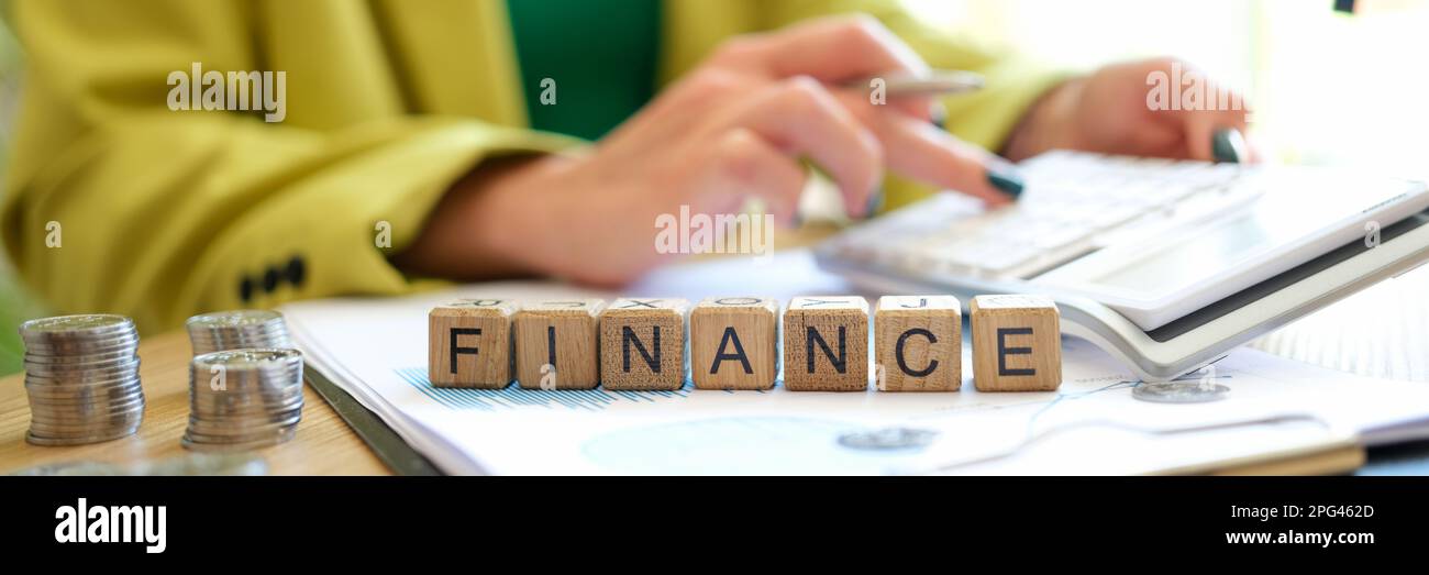 Finance text on cubes and working businesswoman with calculator Stock ...