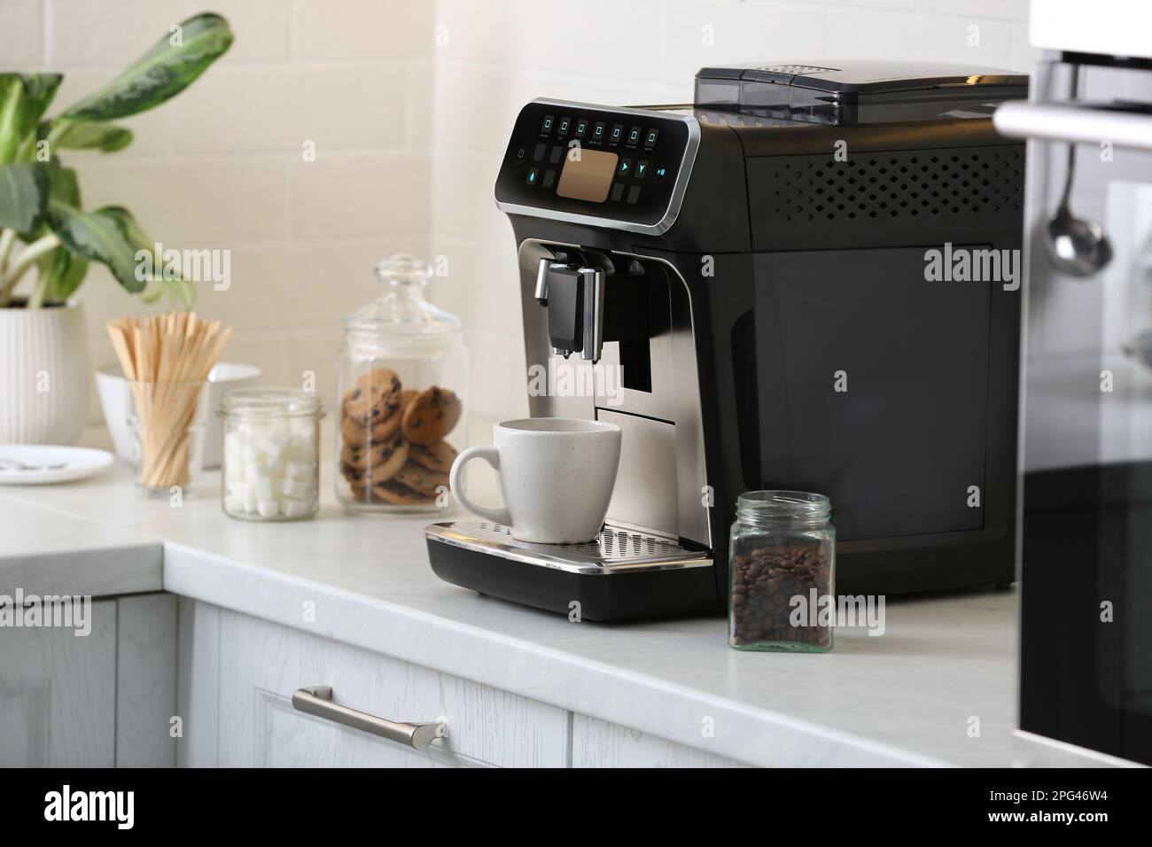 Modern electric coffee machine with cup on white countertop in kitchen ...