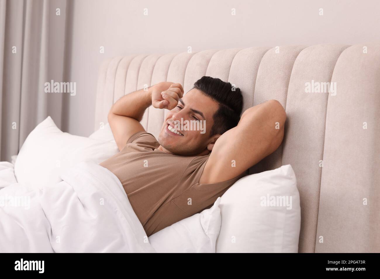 Happy man awakening in bed at home Stock Photo - Alamy