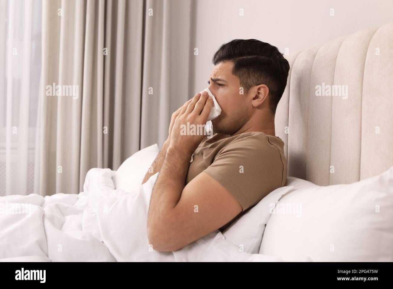 Sick man with tissue suffering from cold in bed at home Stock Photo - Alamy