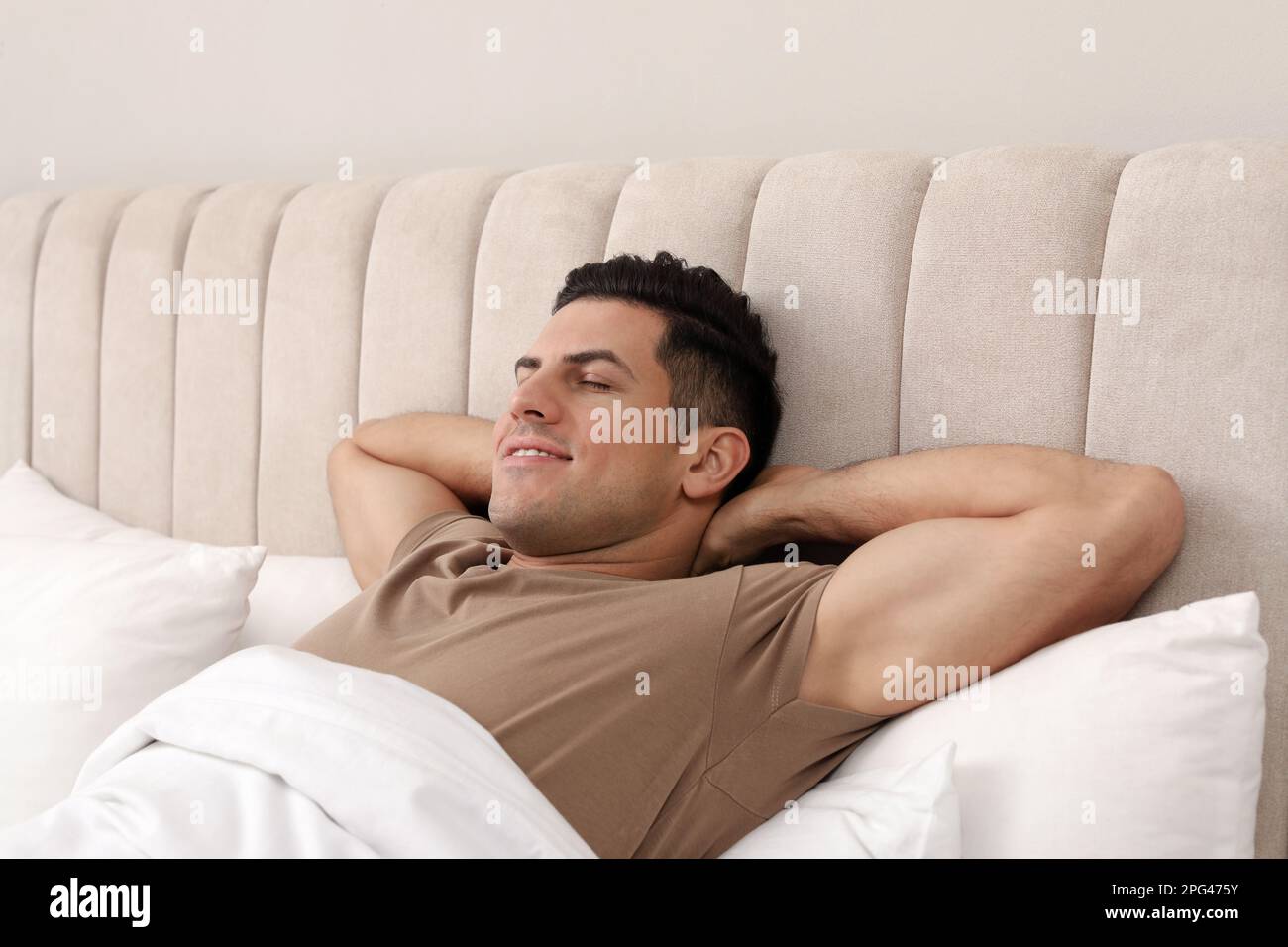 Happy man lying in bed at home Stock Photo - Alamy