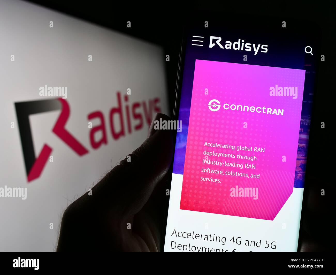 Person holding cellphone with webpage of US technology company Radisys ...