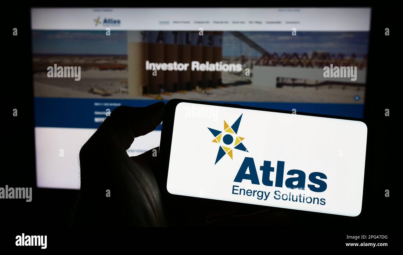 Person holding cellphone with logo of US oil and gas company Atlas ...