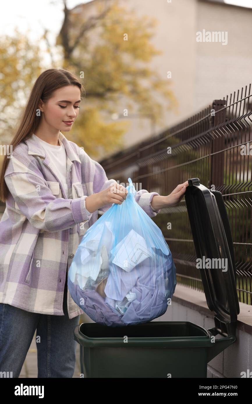 Woman putting garbage bag hi-res stock photography and images - Alamy