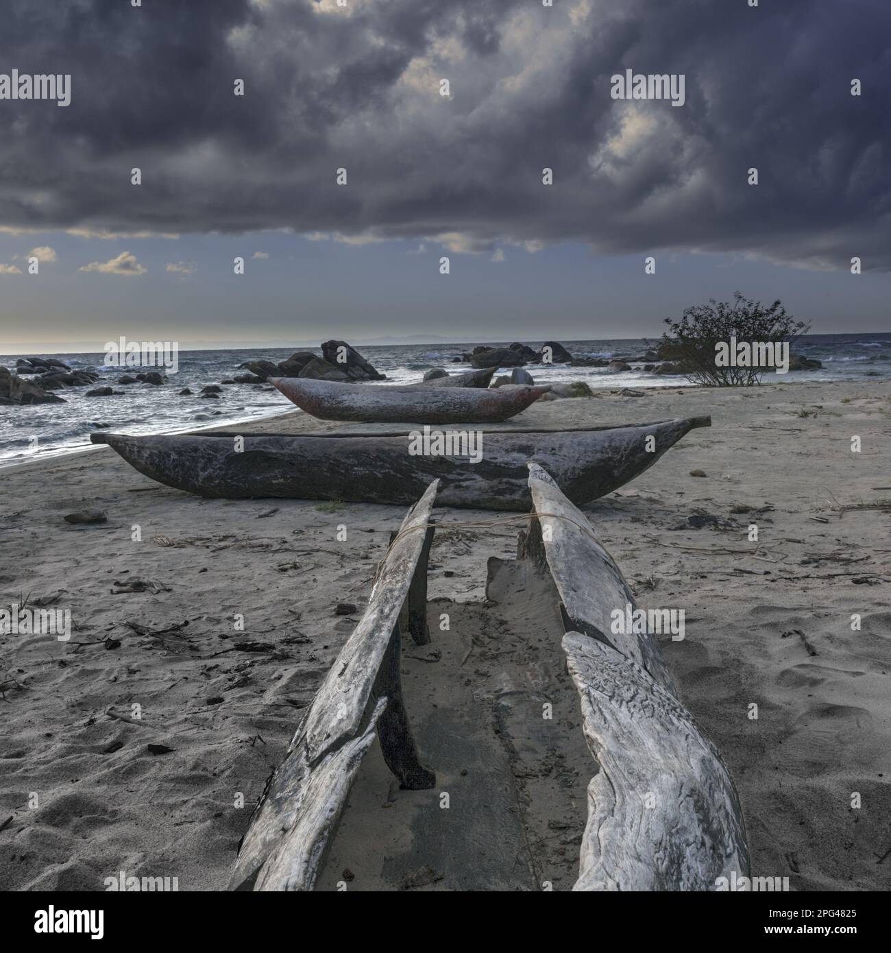 Abandoned and broken Mokoro fishing boats lie on a beach at Benga along ...