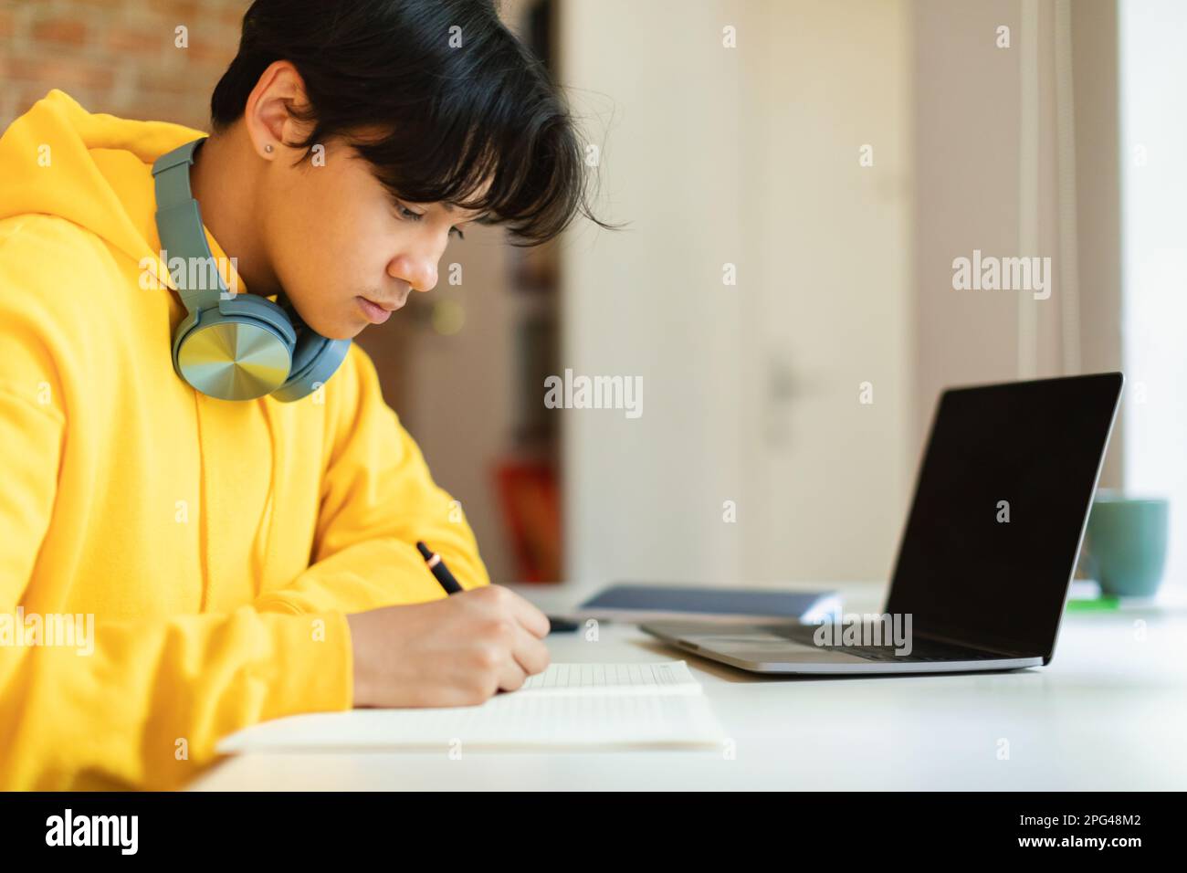 Asian Teen Guy At Laptop Doing Homework Indoors, Side View Stock Photo ...