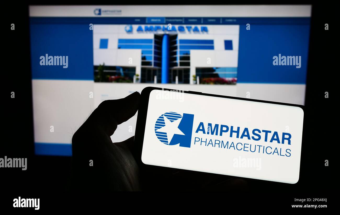 Person holding mobile phone with logo of American company Amphastar Pharmaceuticals Inc. on ...