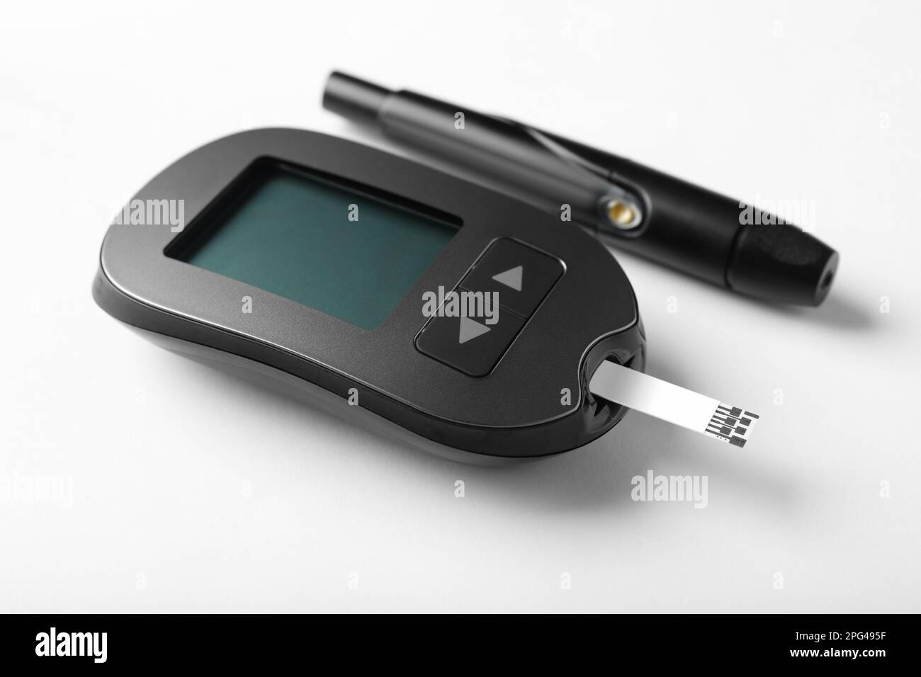Digital glucometer with test strip and lancet pen on white background ...