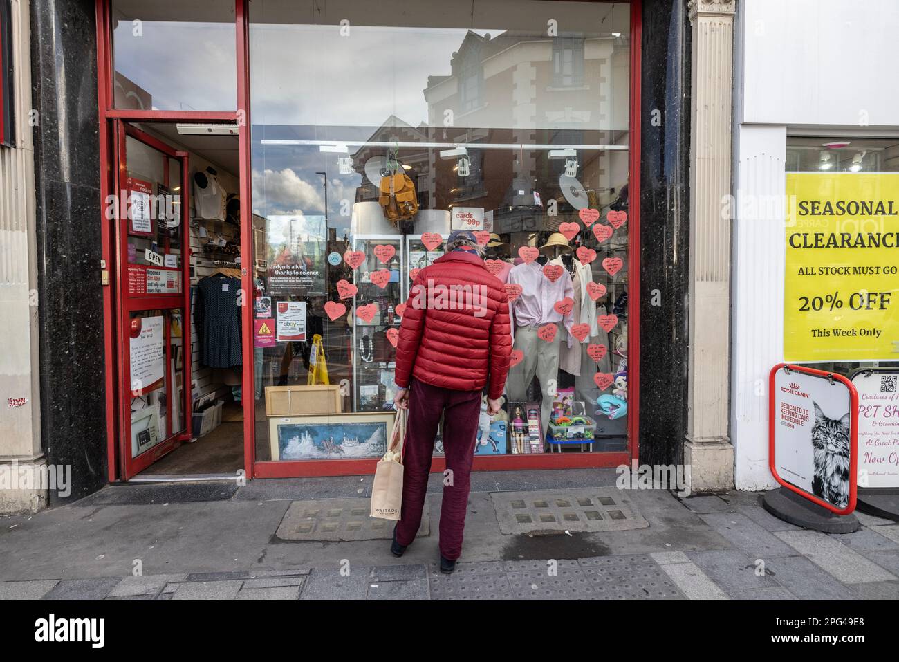 Man looking into charity shop window display hi-res stock photography ...