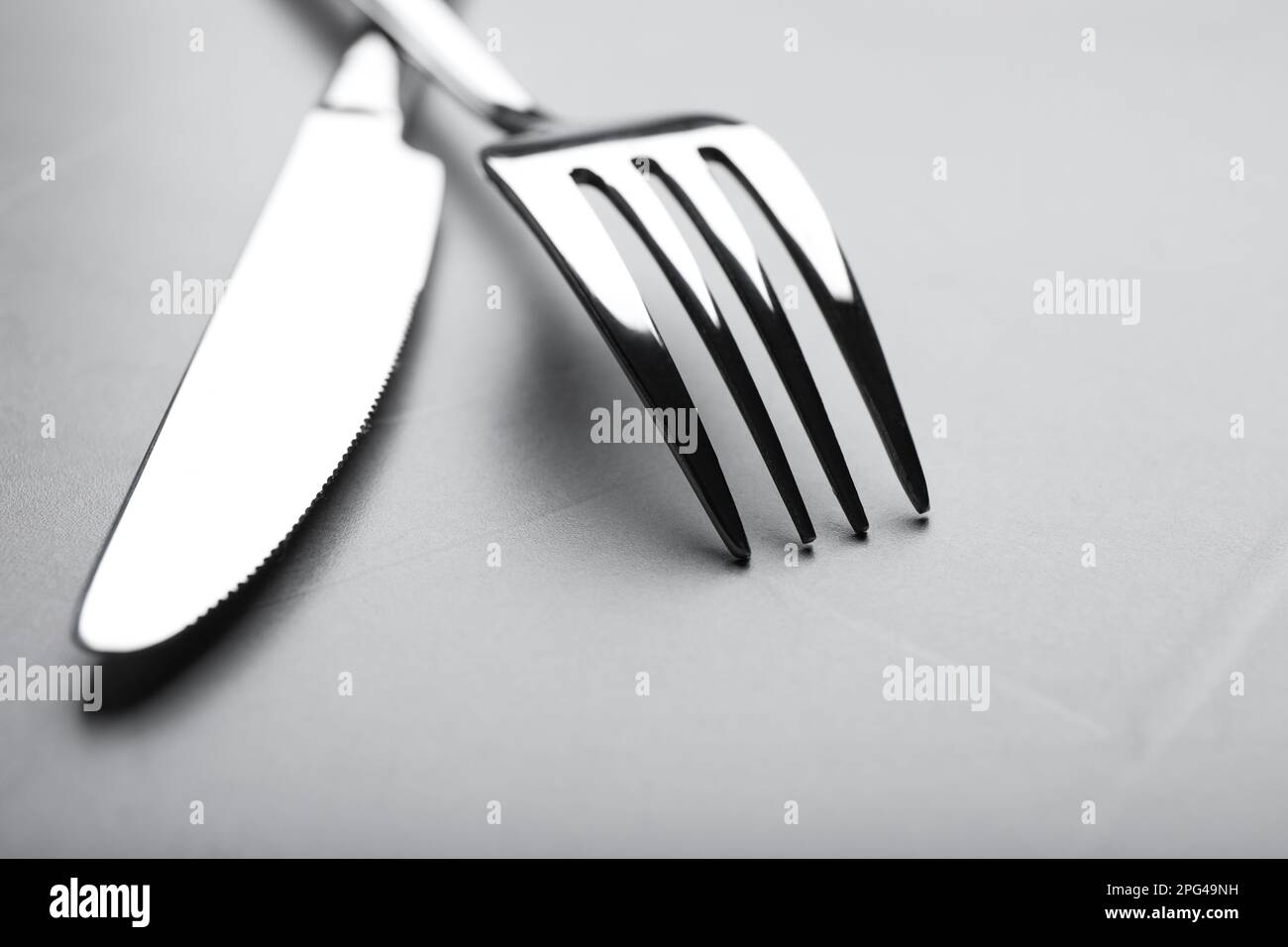 Shiny fork and knife on grey table, closeup Stock Photo - Alamy
