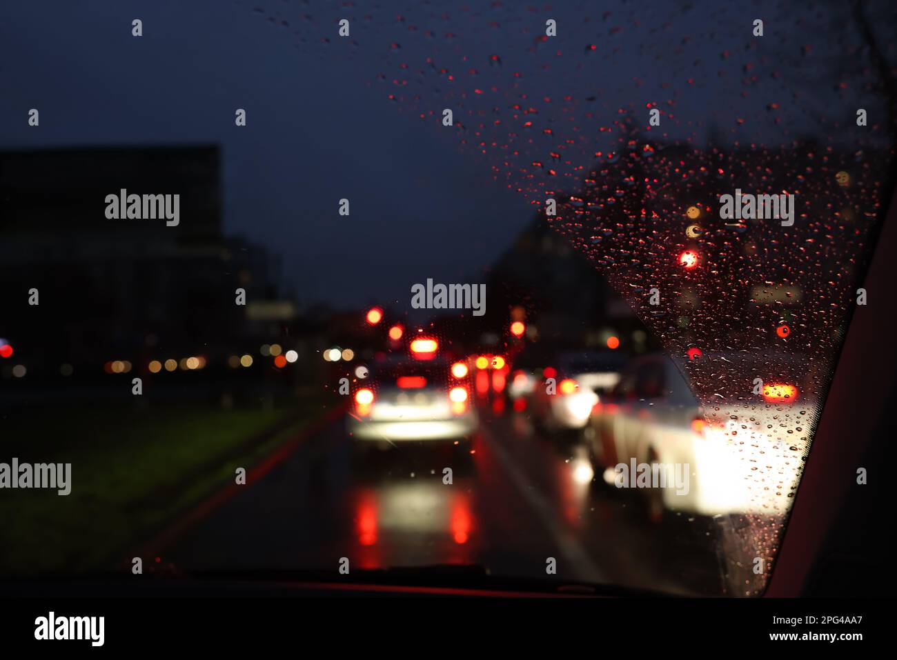 Blurred view of road through wet car window at night. Bokeh effect ...