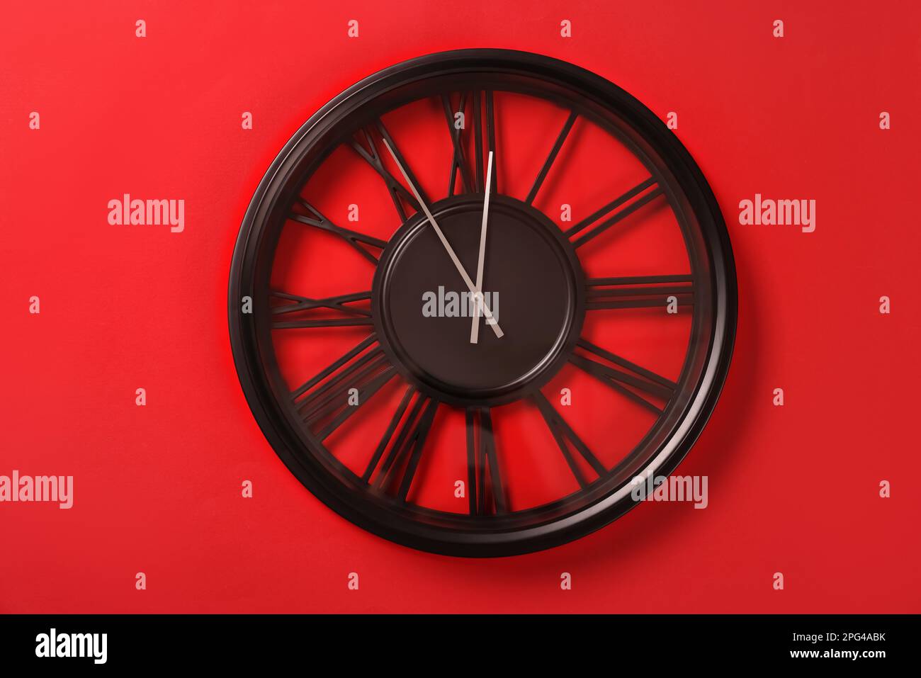 Clock showing five minutes until midnight on red background. New Year ...