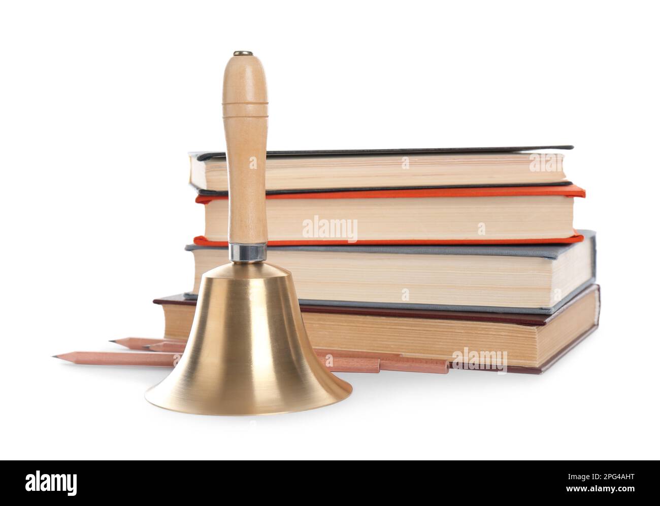 Golden school bell with wooden handle and stack of books on white ...
