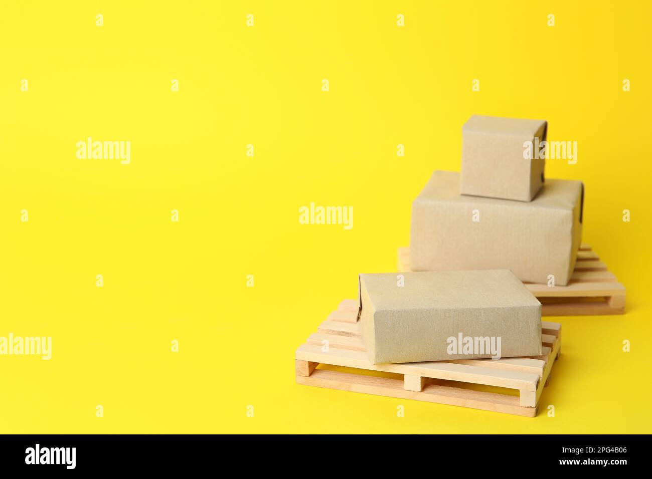 Wooden pallets and boxes on yellow background, space for text Stock ...