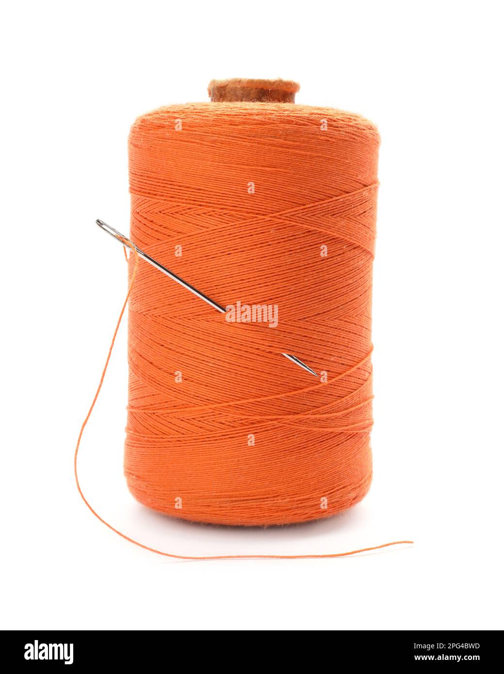Orange sewing thread with needle on white background Stock Photo - Alamy