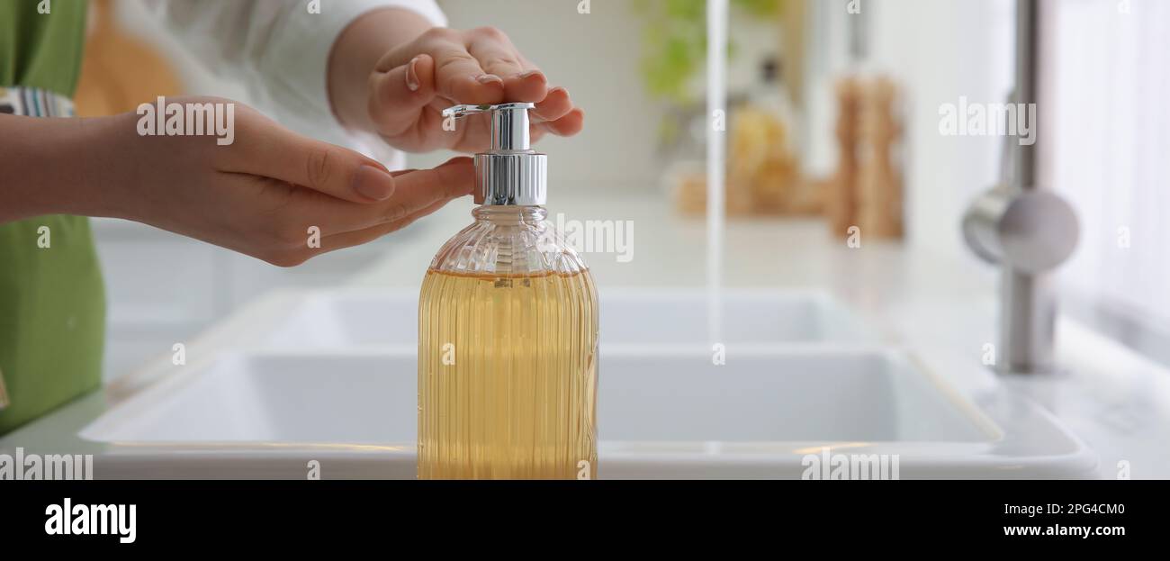 Woman applying liquid soap on hand indoors, closeup. Banner design ...
